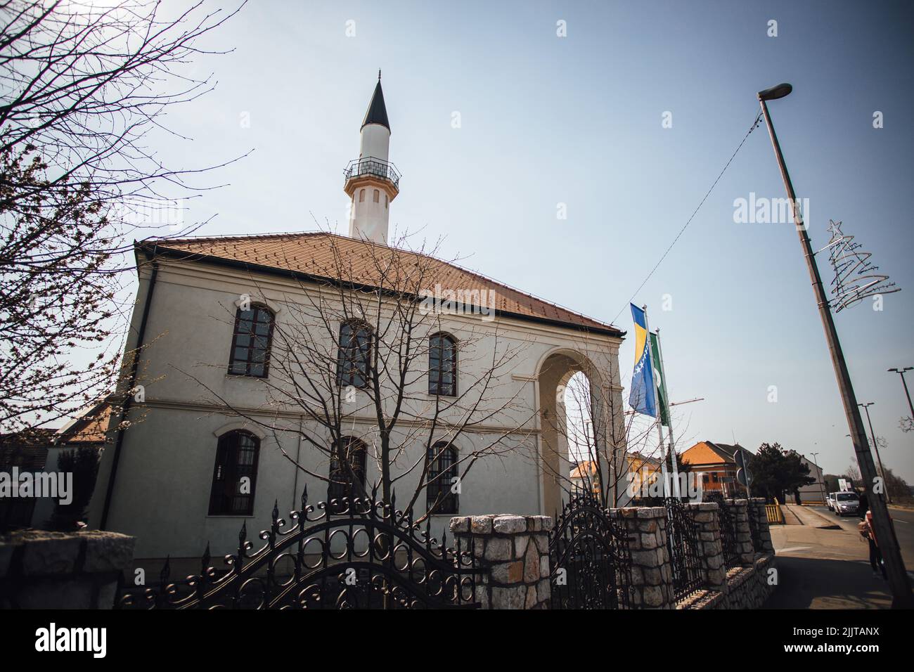 A beautiful shot of the exterior design of Atik mosque with flags in ...