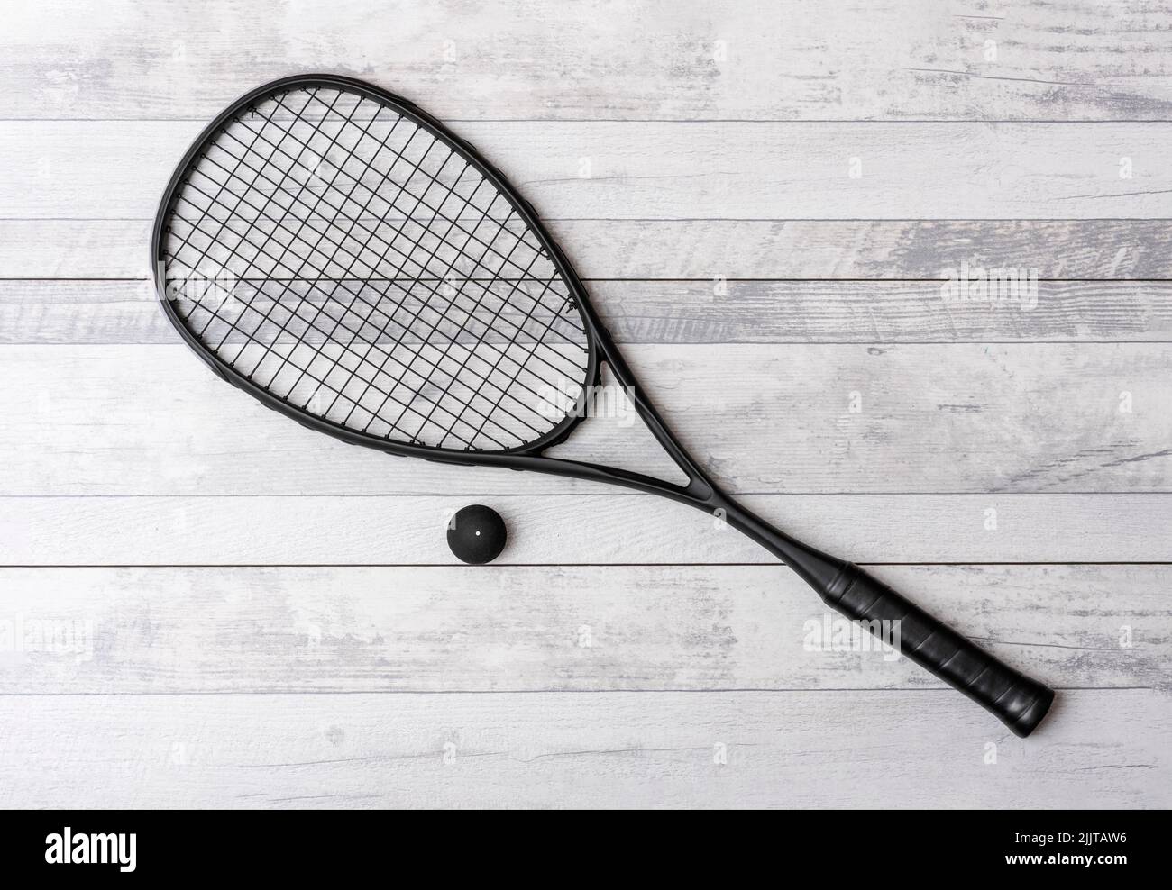 Black squash racket and ball on grey court. Horizontal sport theme ...