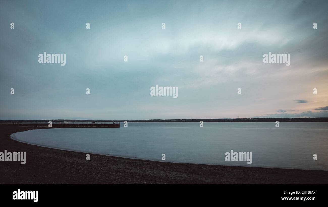 A mesmerizing scene of large lake under dramatic gray sky Stock Photo ...