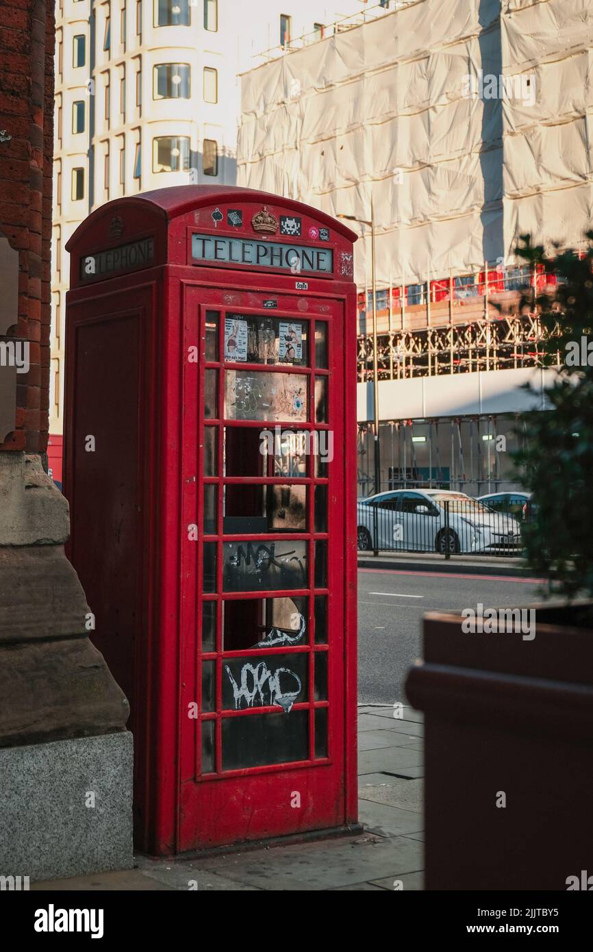 A vertical shot of a Red telephone cabin in London, United Kingdom in ...