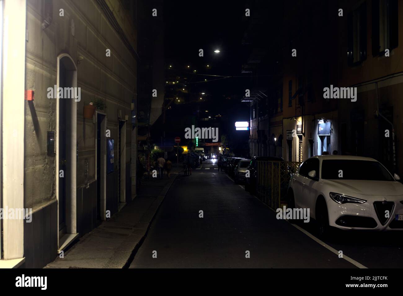Street at night with closed shops and glowing signs and shop windows ...