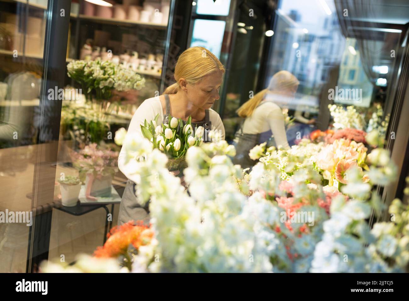 flower shop manager checks the quality of products in the refrigerator ...