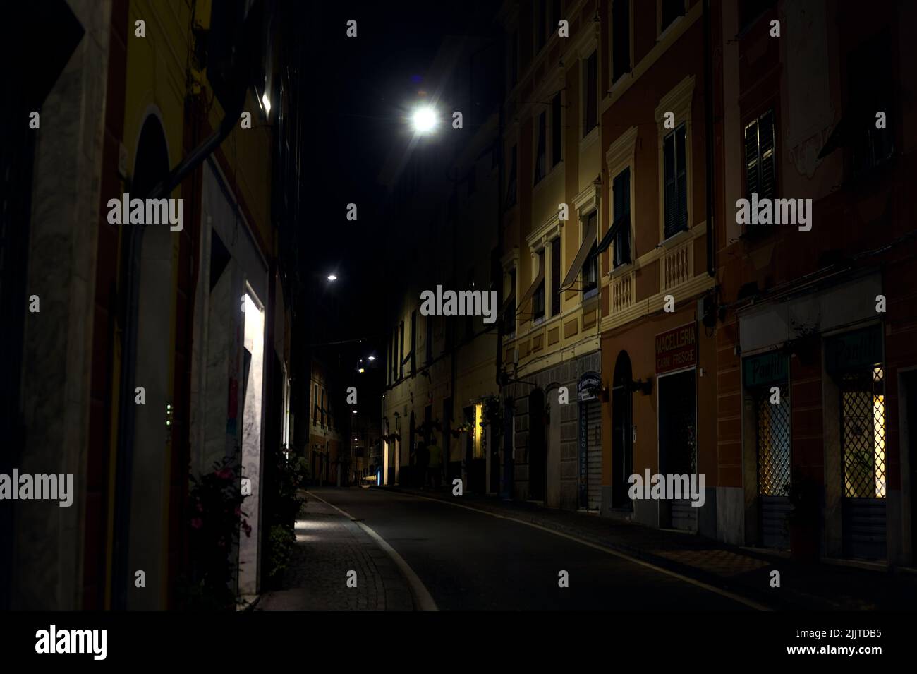 Street at night with closed shops and glowing signs and shop windows ...
