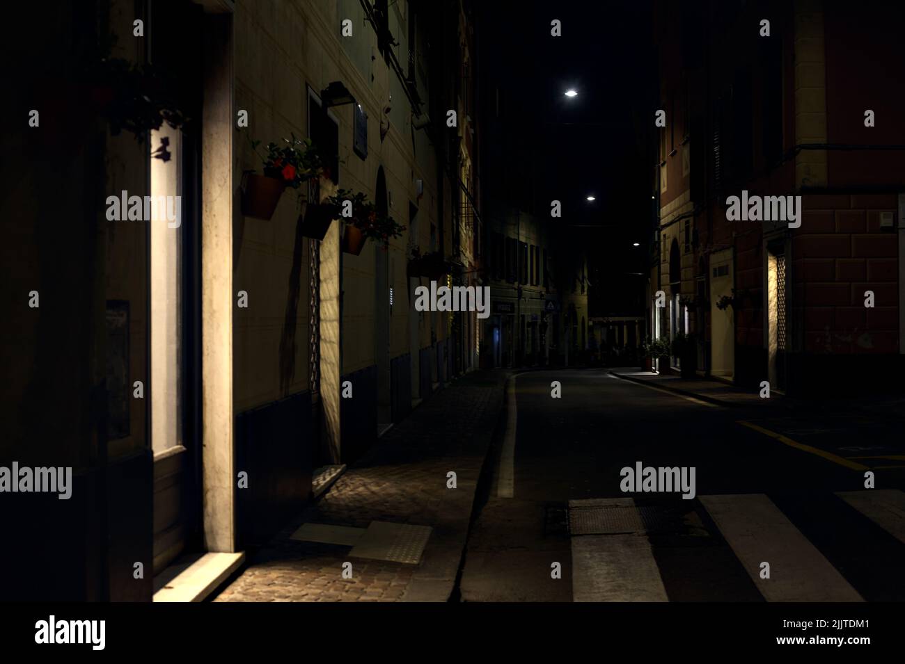 Street at night with closed shops and glowing signs and shop windows ...