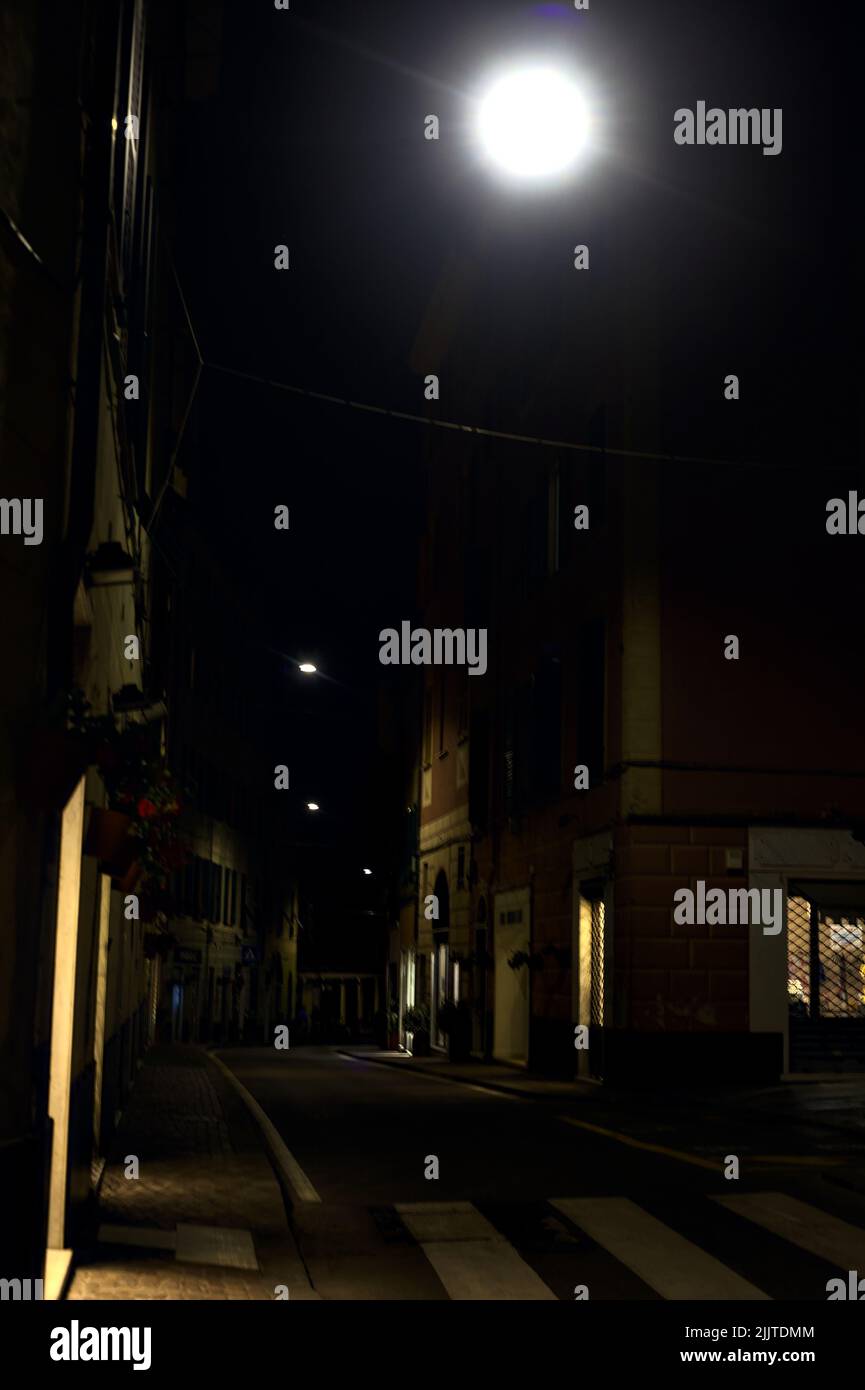 Street at night with closed shops and glowing signs and shop windows ...