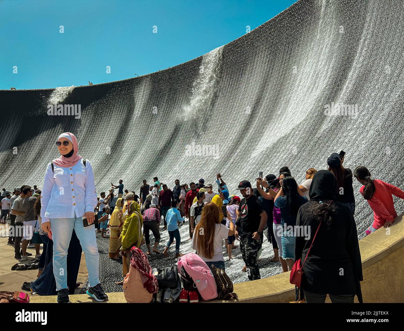 A shot of people standing under a surreal water feature in expo 2020 ...