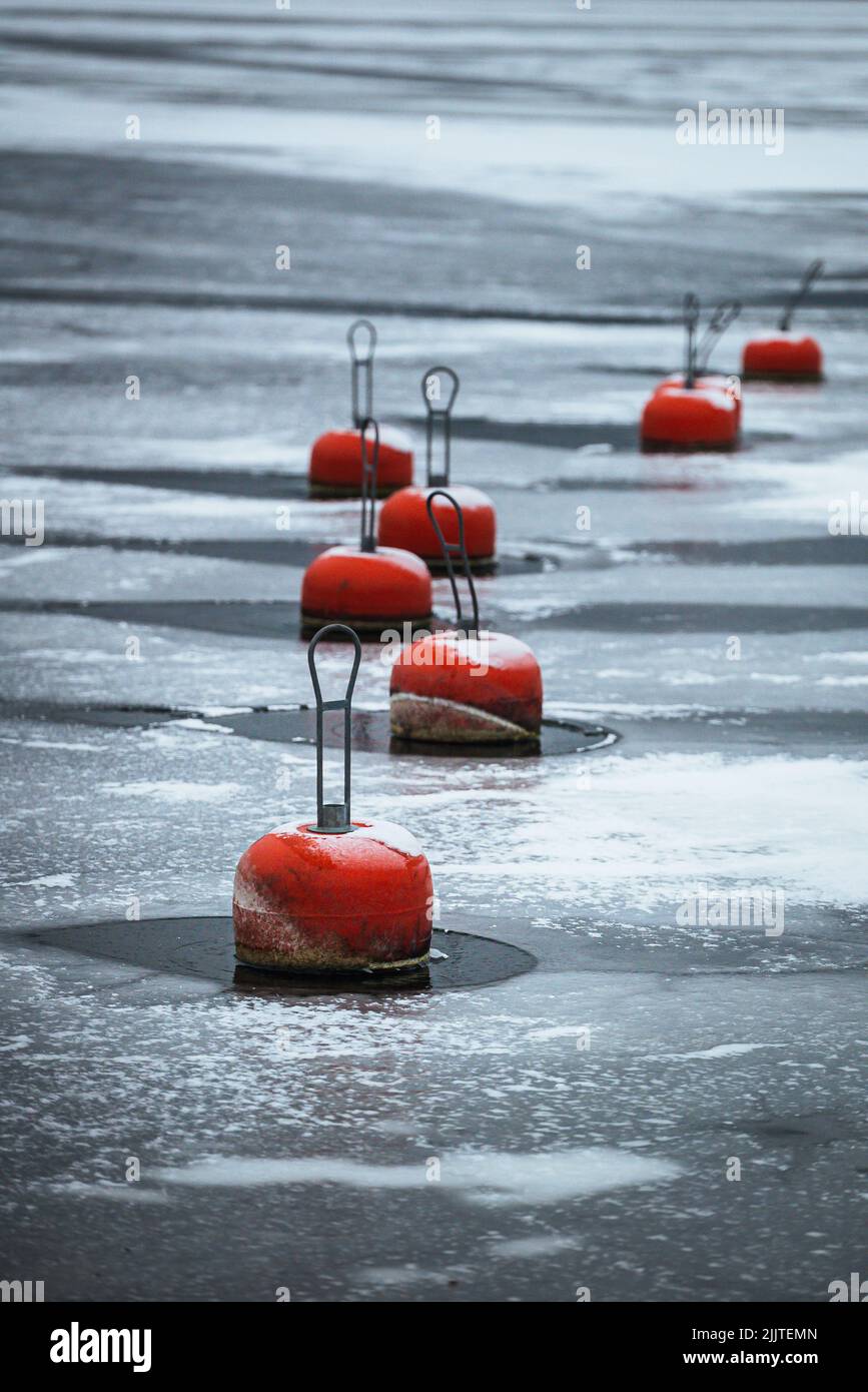 A vertical shot of red buoys in the frozen sea Stock Photo - Alamy