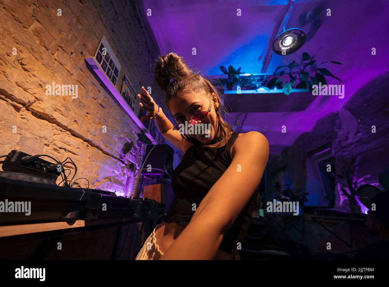 Beautiful female DJ dancing to techno in a small club Stock Photo - Alamy