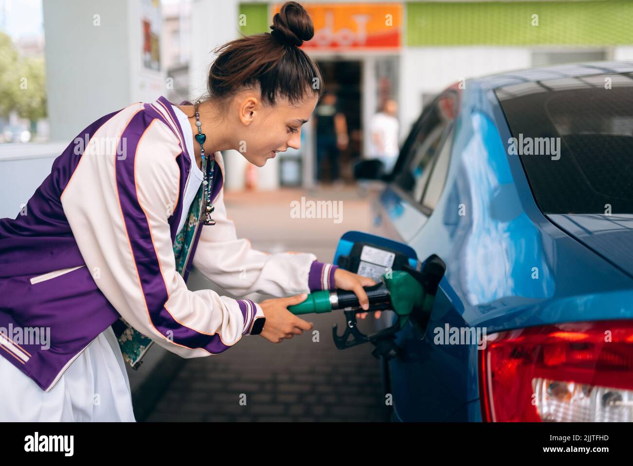 Woman filling her car with fuel at a gas station Stock Photo - Alamy