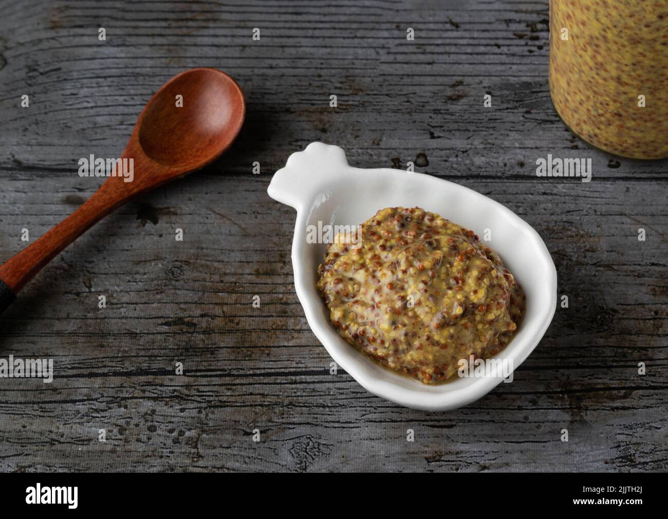 Old mustard on a white plate in rustic background Stock Photo - Alamy