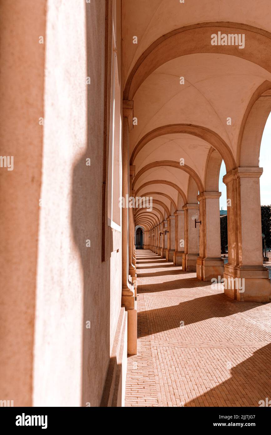 A passage with arch top and columns with shadow on ground in the ...