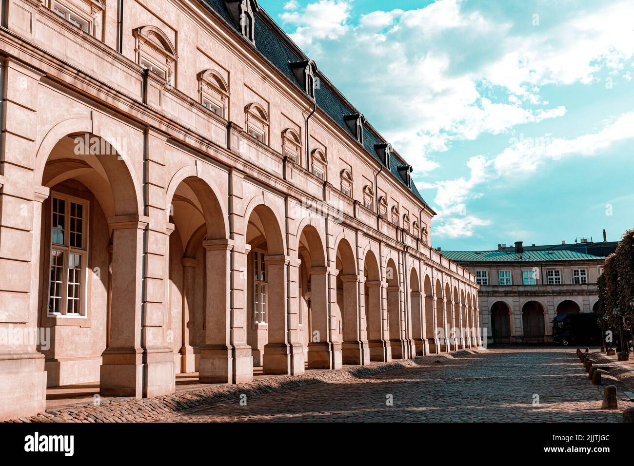 The exterior design of a big classic building under cloudy sky and the ...