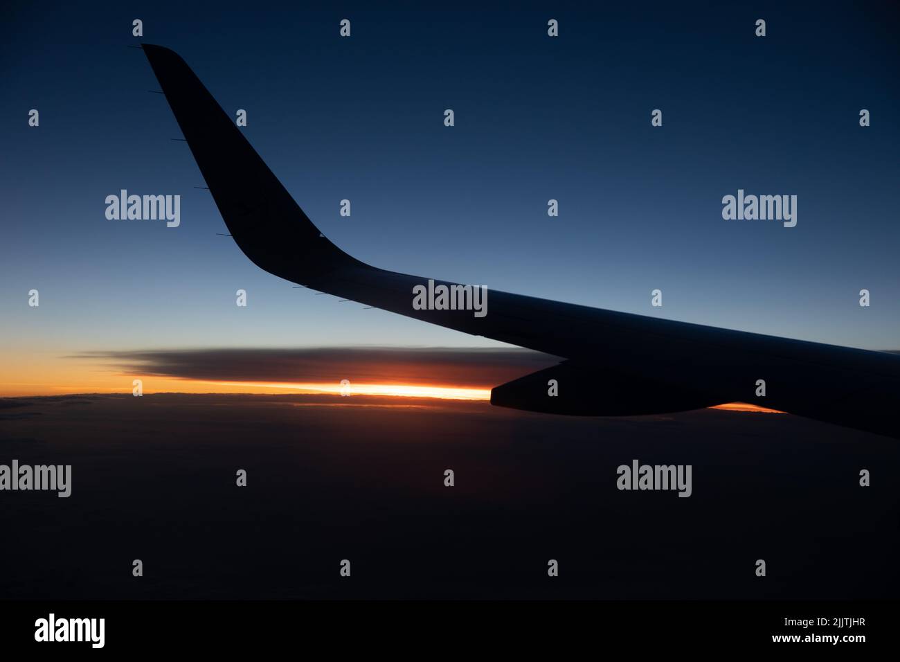 The silhouette of the left-wing and winglet of an aircraft against a ...