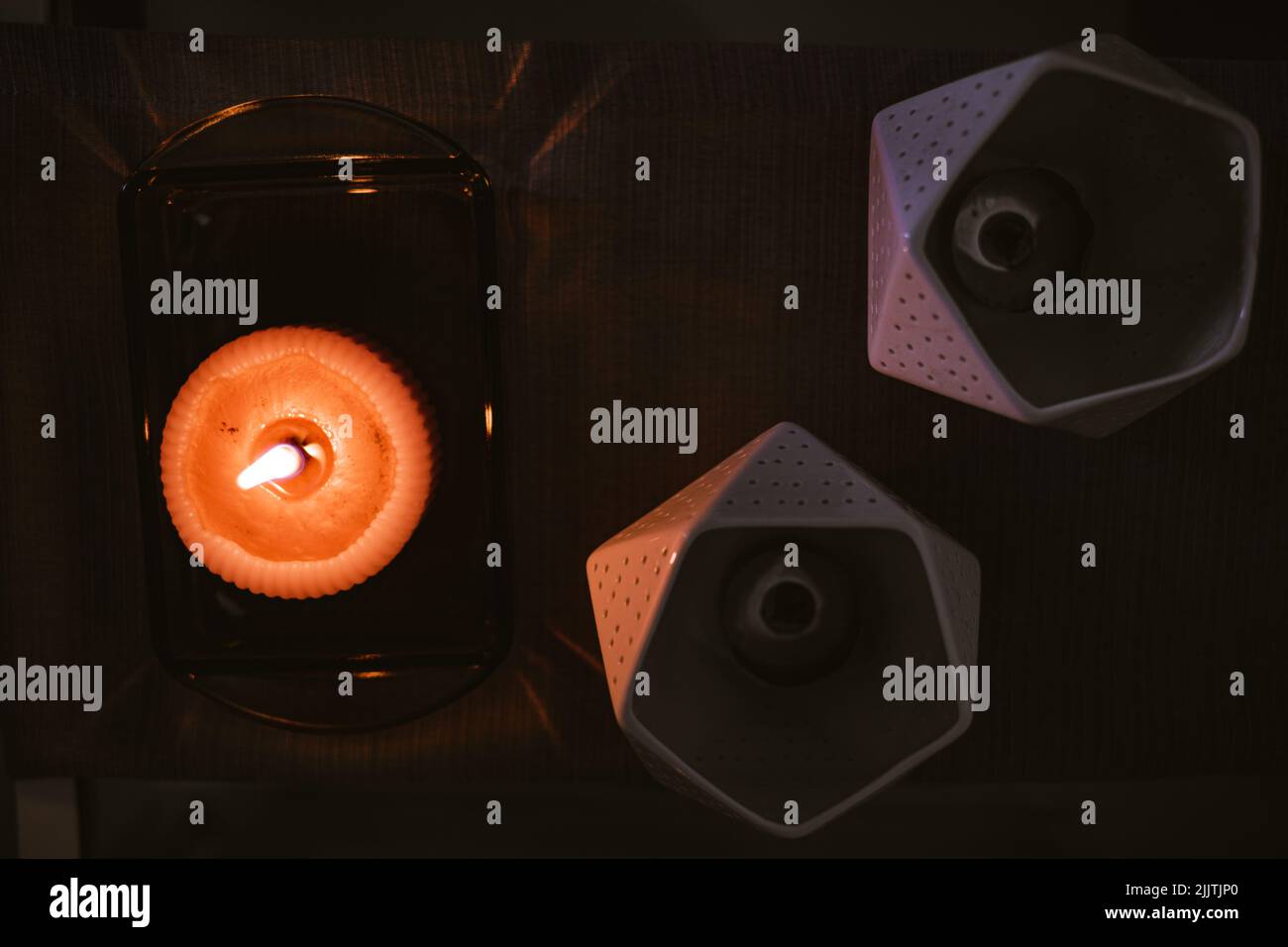 A top view of burning candle on a decorative tray and candle holders ...