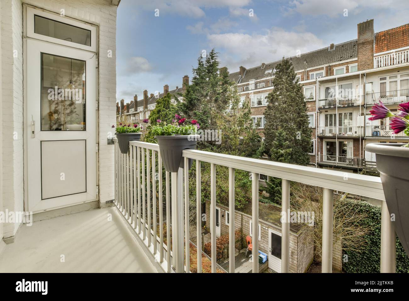 Front view of old brick buildings and from small balcony with railings ...