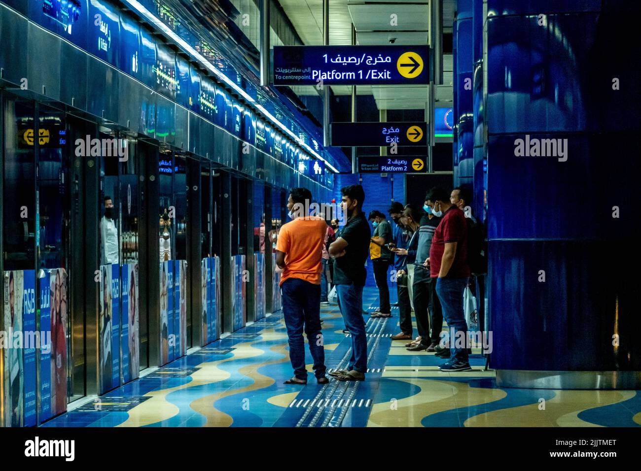 Several passengers waiting for the metro to arrive in Dubai Metro, UAE ...