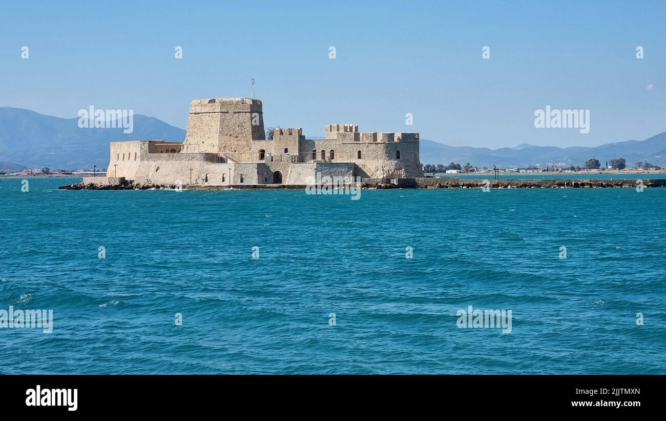 The Bourtzi Castle island in Greece on blue sky background Stock Photo ...