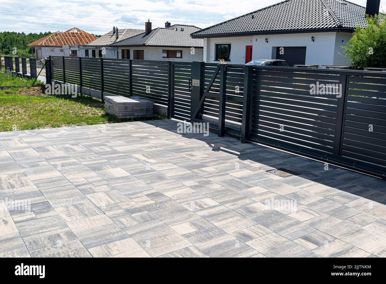 A modern panel fence in anthracite color, a visible sliding gate to the ...