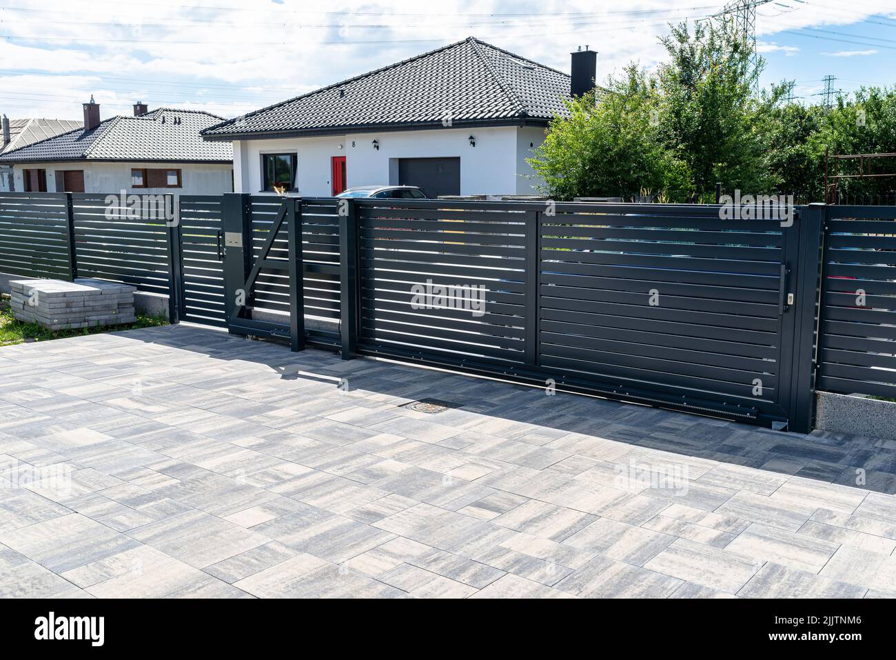 A modern panel fence in anthracite color, a visible sliding gate to the ...