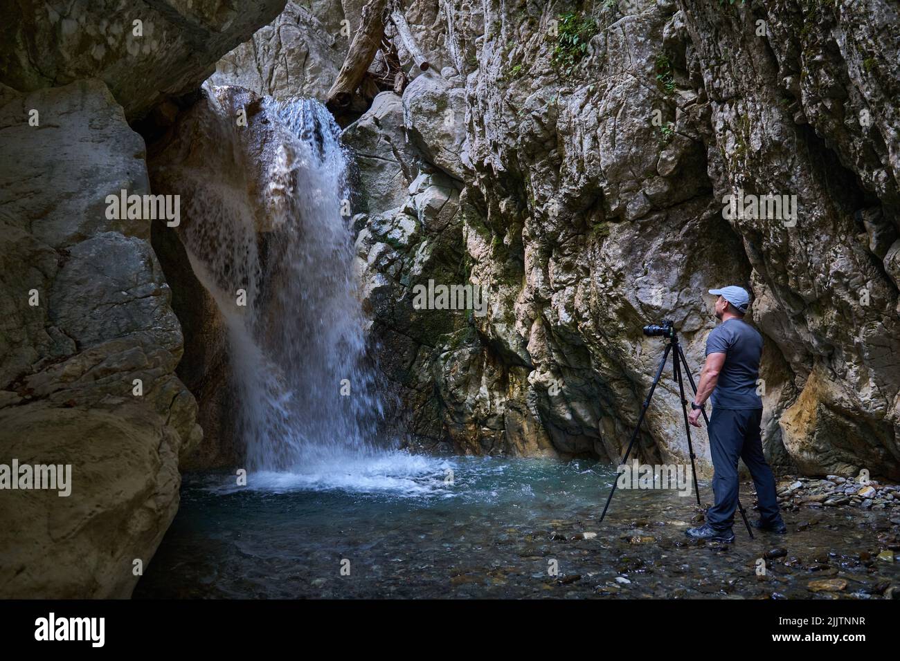 Nature photographer shooting a waterfall in a canyon Stock Photo - Alamy