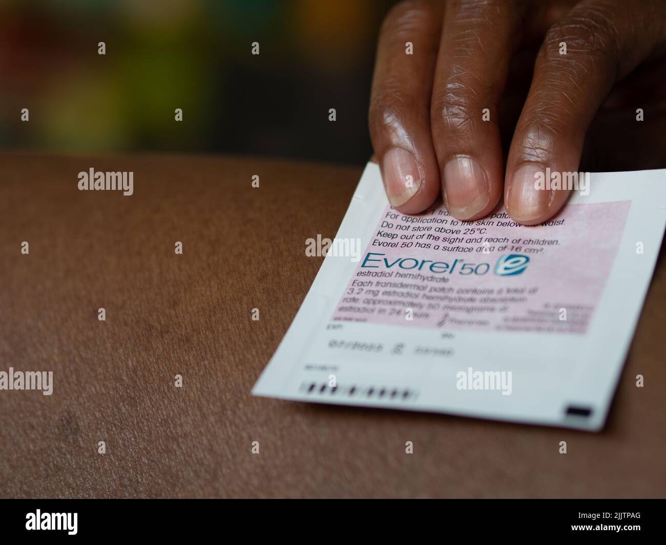 Evorel HRT Patch being held against the skin of a woman of colour Stock ...