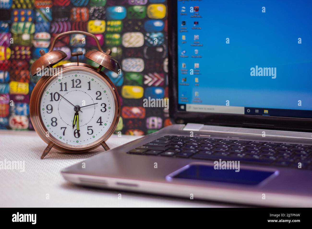 BRONZE ANTIQUE CLOCK AND LAPTOP WITH COLORFUL BACKDROP WITH A NICE ...