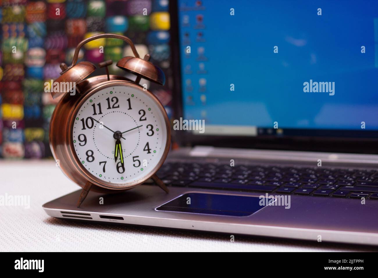 BRONZE ANTIQUE CLOCK AND LAPTOP WITH COLORFUL BACKDROP WITH A NICE ...