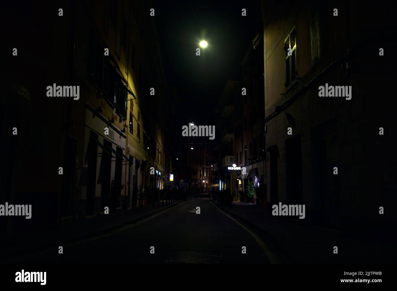 Street at night with closed shops and glowing signs and shop windows ...