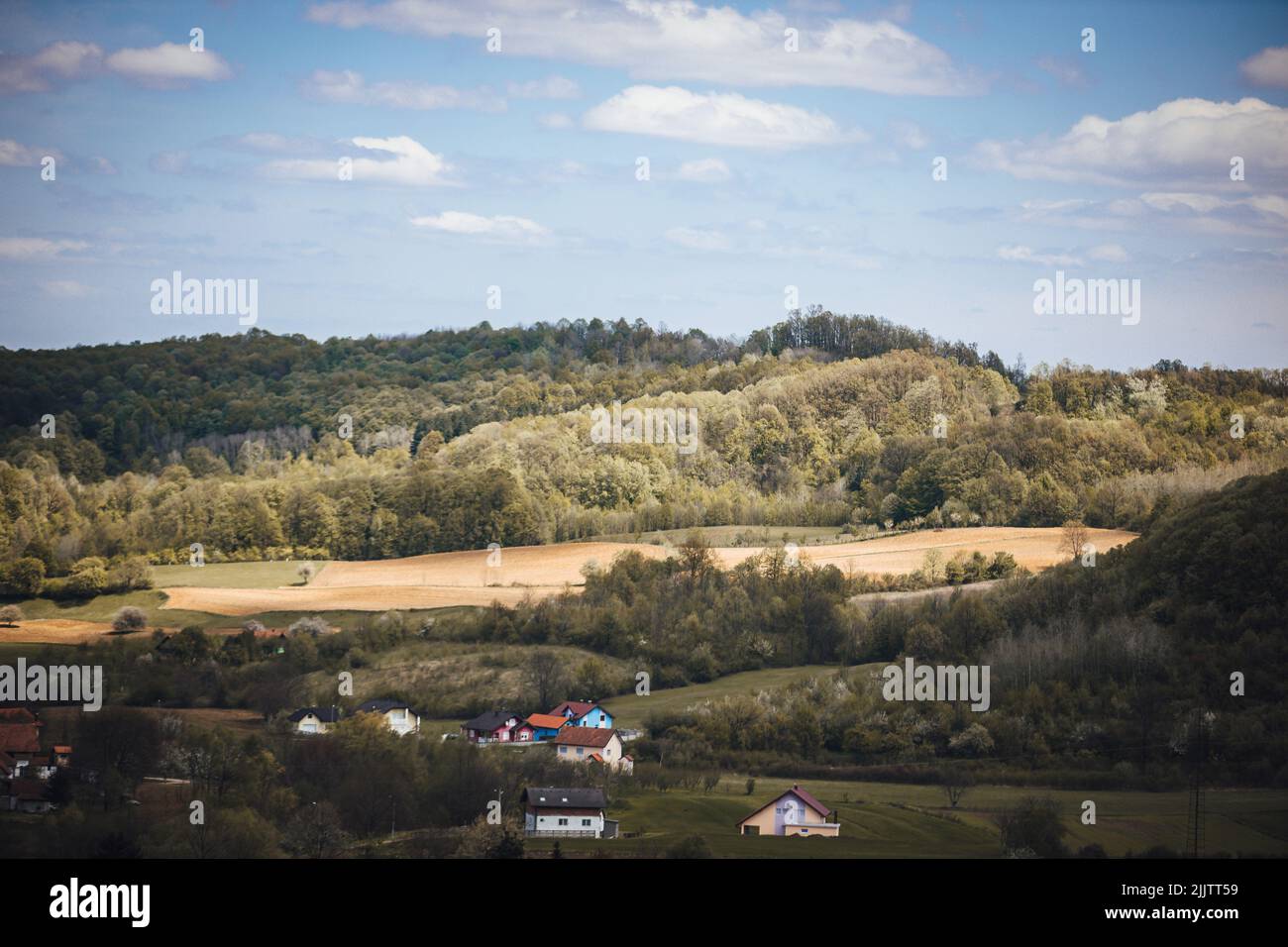 A landscape of a town surrounded by greenery under a cloudy sky in the ...