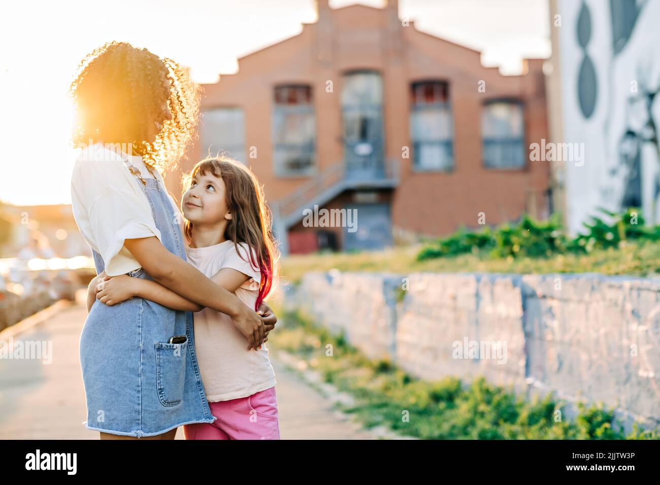 Babysitter young woman and cute school girl having fun together outside ...