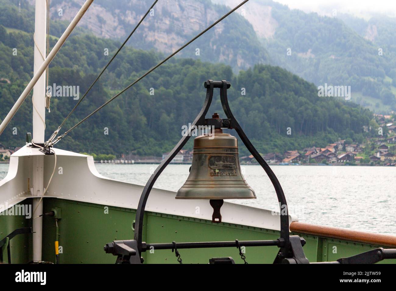A closeup of the bell on a boat against the background of Lake Brienz ...