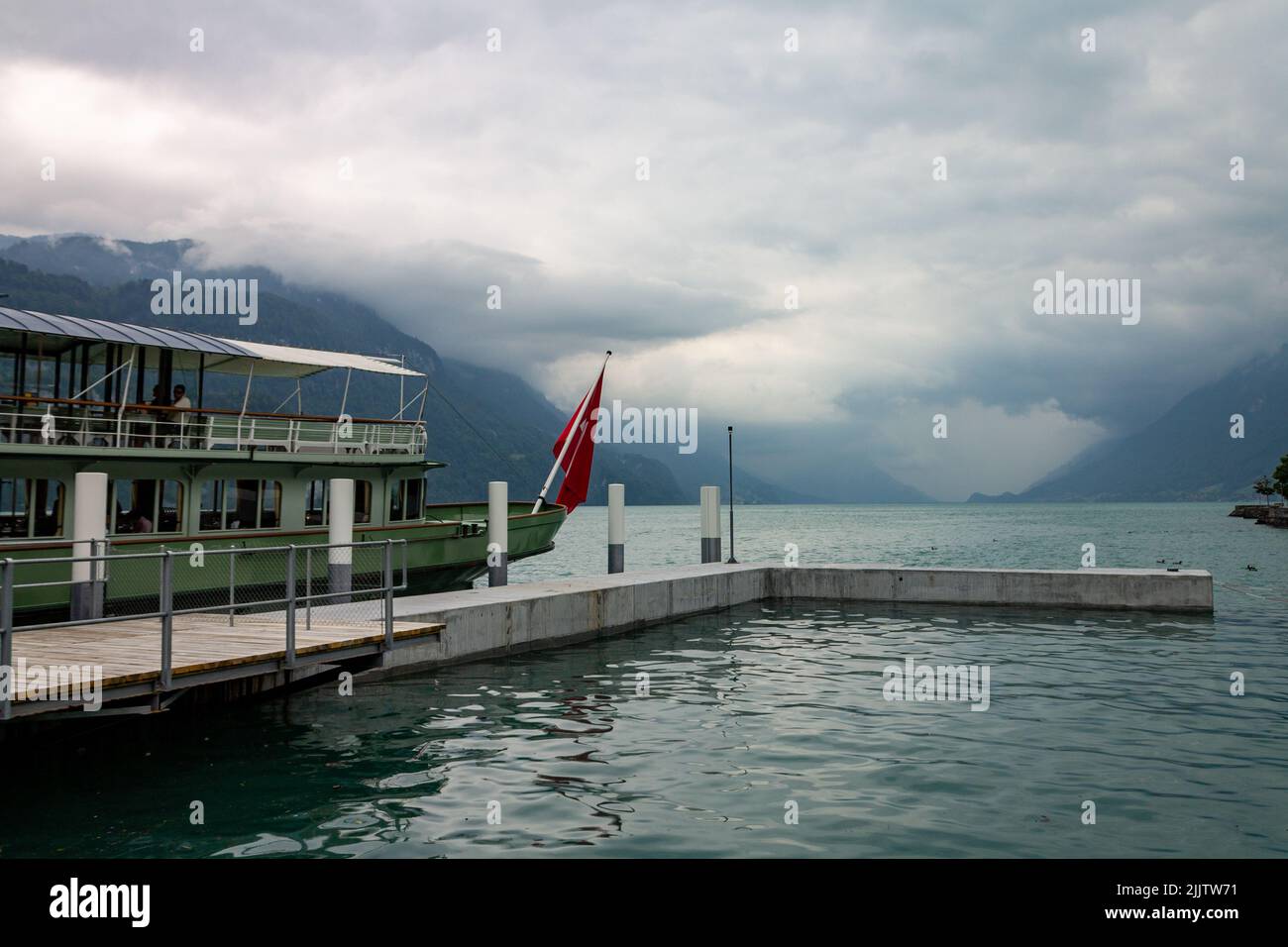 The ship with the Swiss flag near the pier in Interlaken at the shore ...