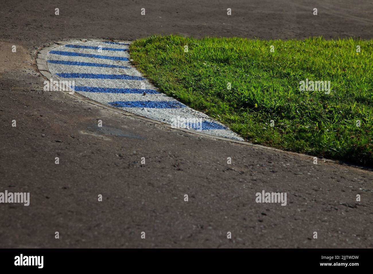The curbstones of a racing track with some nice green grass on the ...