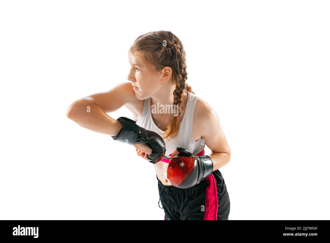 Junior female MMA fighter in sports uniform and gloves training ...