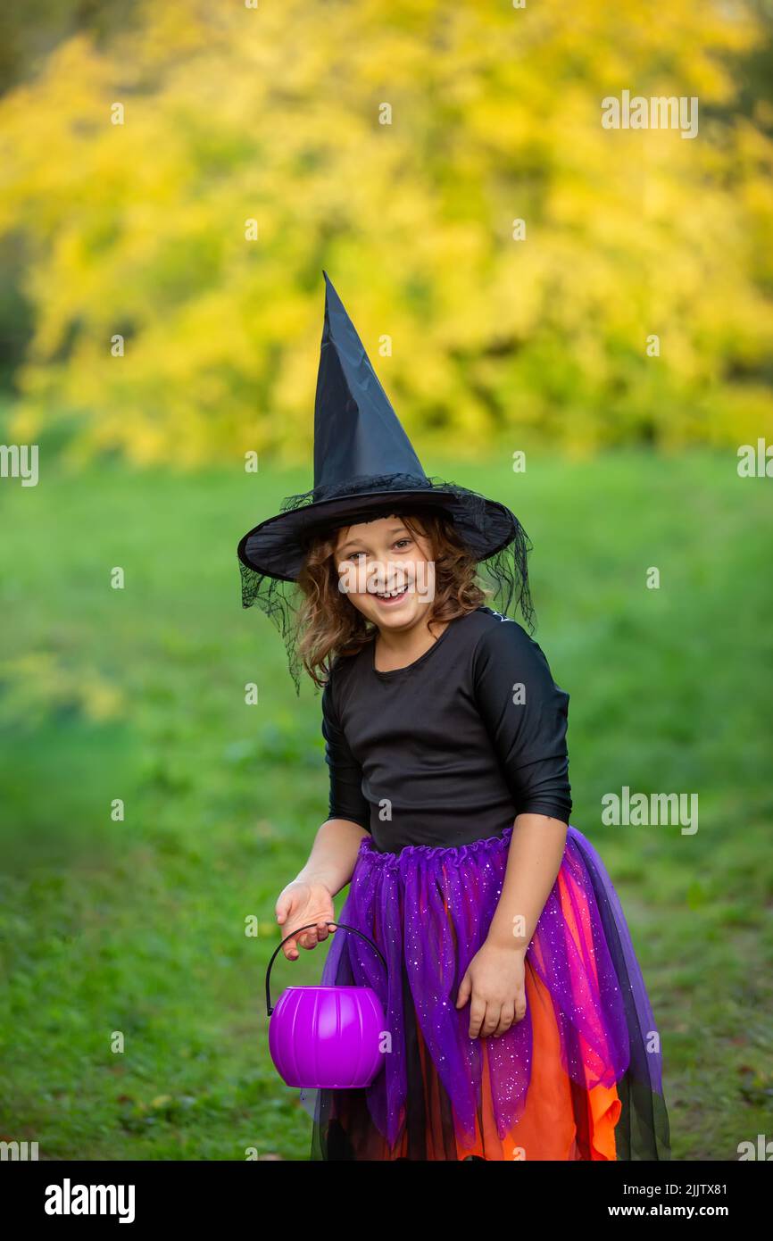 Happy children's Halloween. Smiling little girl witch costume with ...