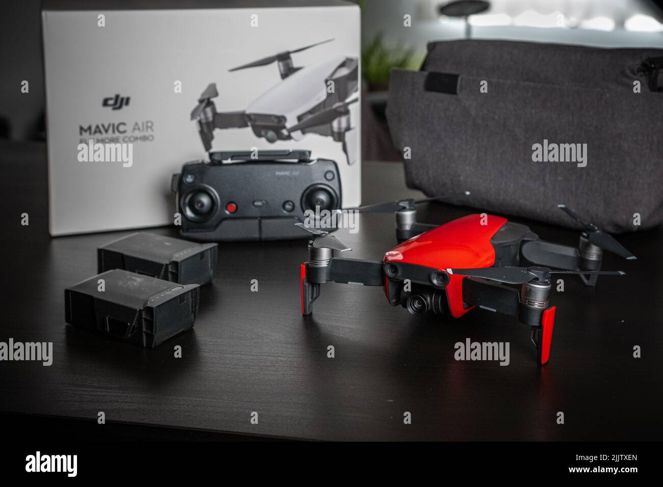 A red drone DJI Mavic Air Fly More Combo with box, a remote, and extra ...