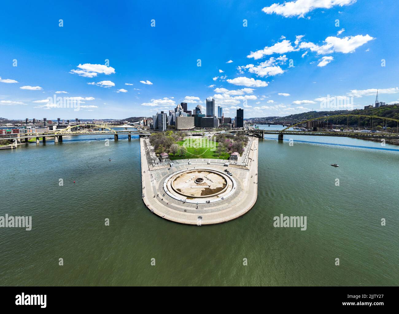 An aerial shot of Point State Park with some skyscrapers and blue sky ...
