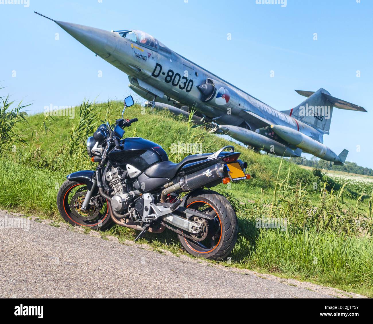 A Honda CB900f motorcycle in front of an out of service jet fighter ...