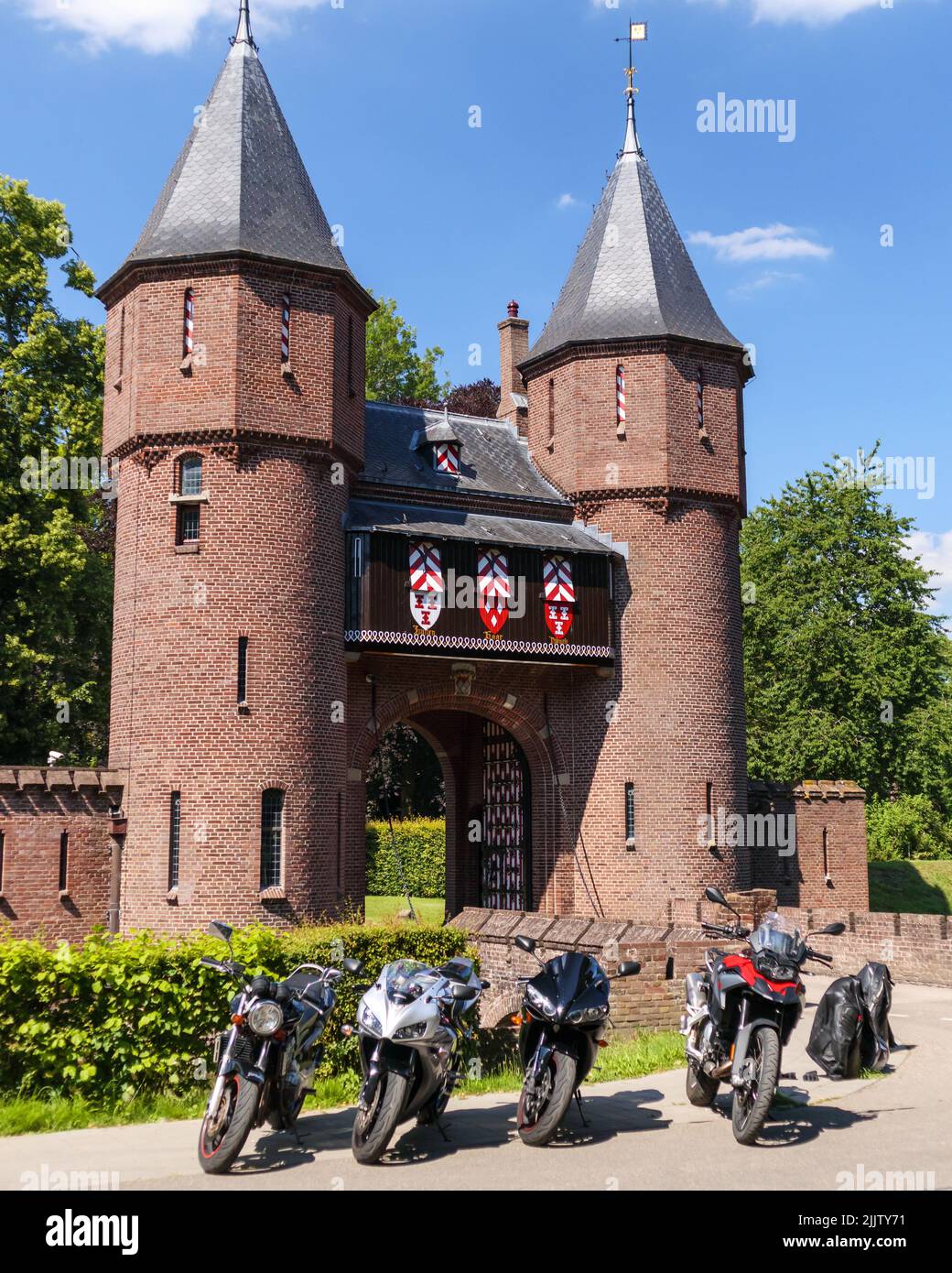 A row of motorcycles in front of the gate of a castle in the ...
