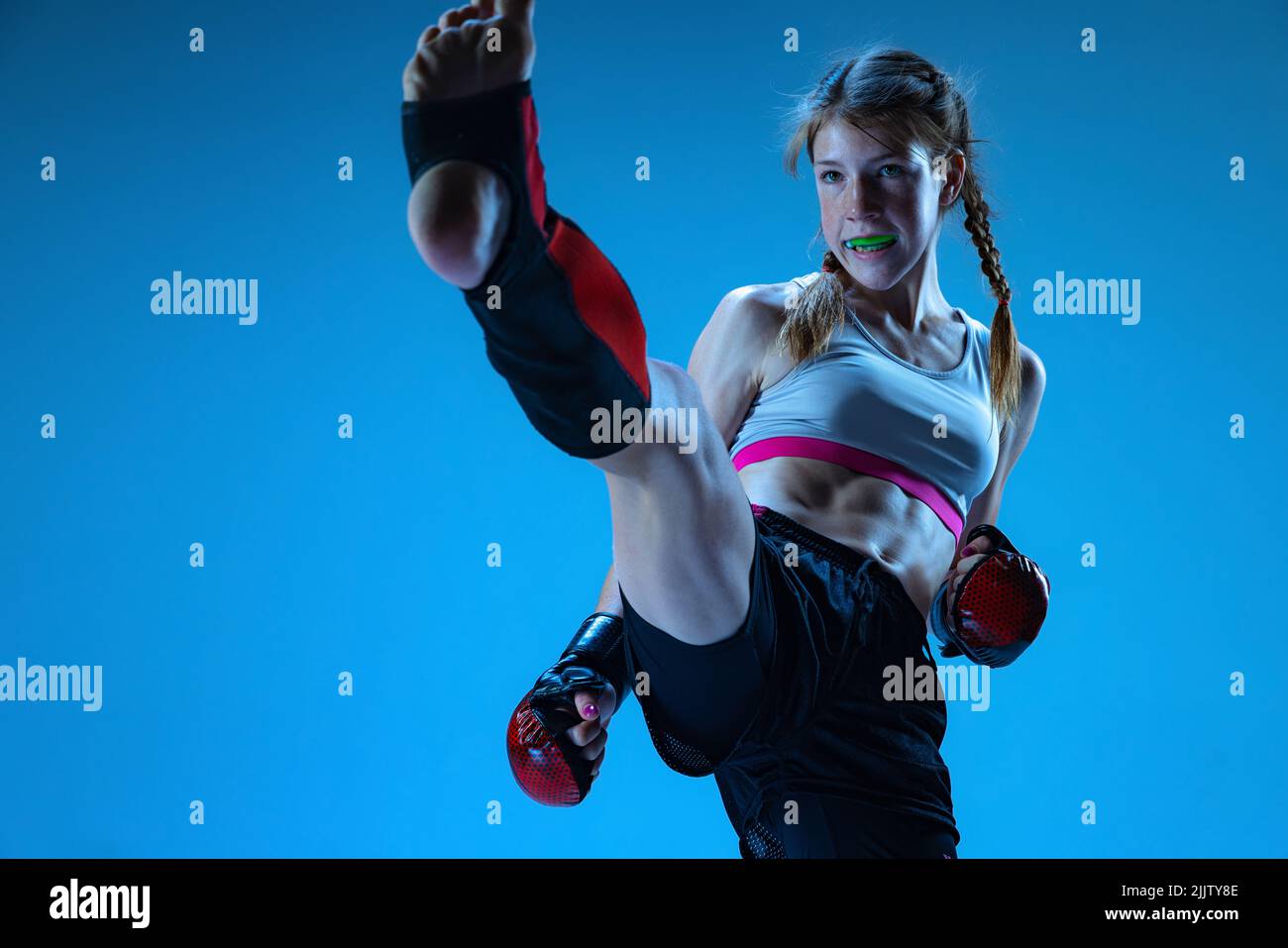 Studio shot of sportive teen-girl, MMA fighter in action, motion ...