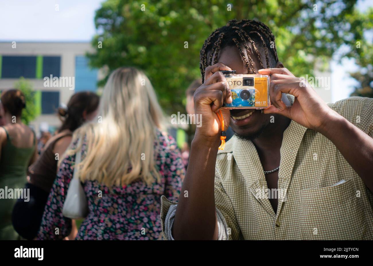 A young black man taking pictures on a disposable camera Stock Photo ...