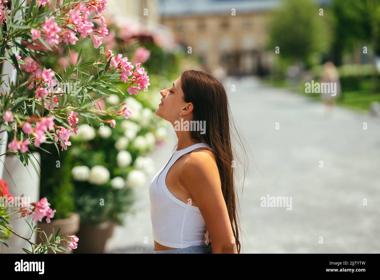 Outdoor portrait of young beautiful lady posing near flowering tree ...