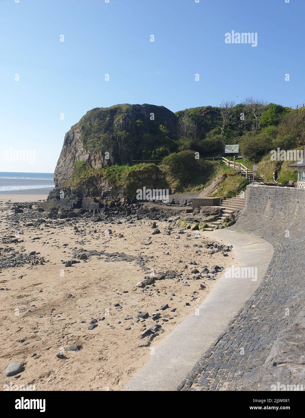 A vertical shot of the sunny rocky Pendine beach, in Carmarthen , South ...