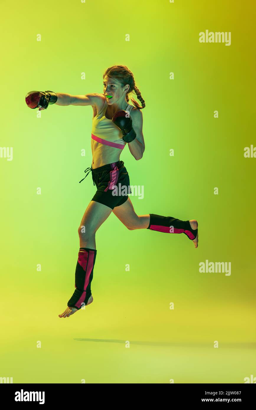 Dynamic portrait of athletic girl, MMA fighter training isolated on ...