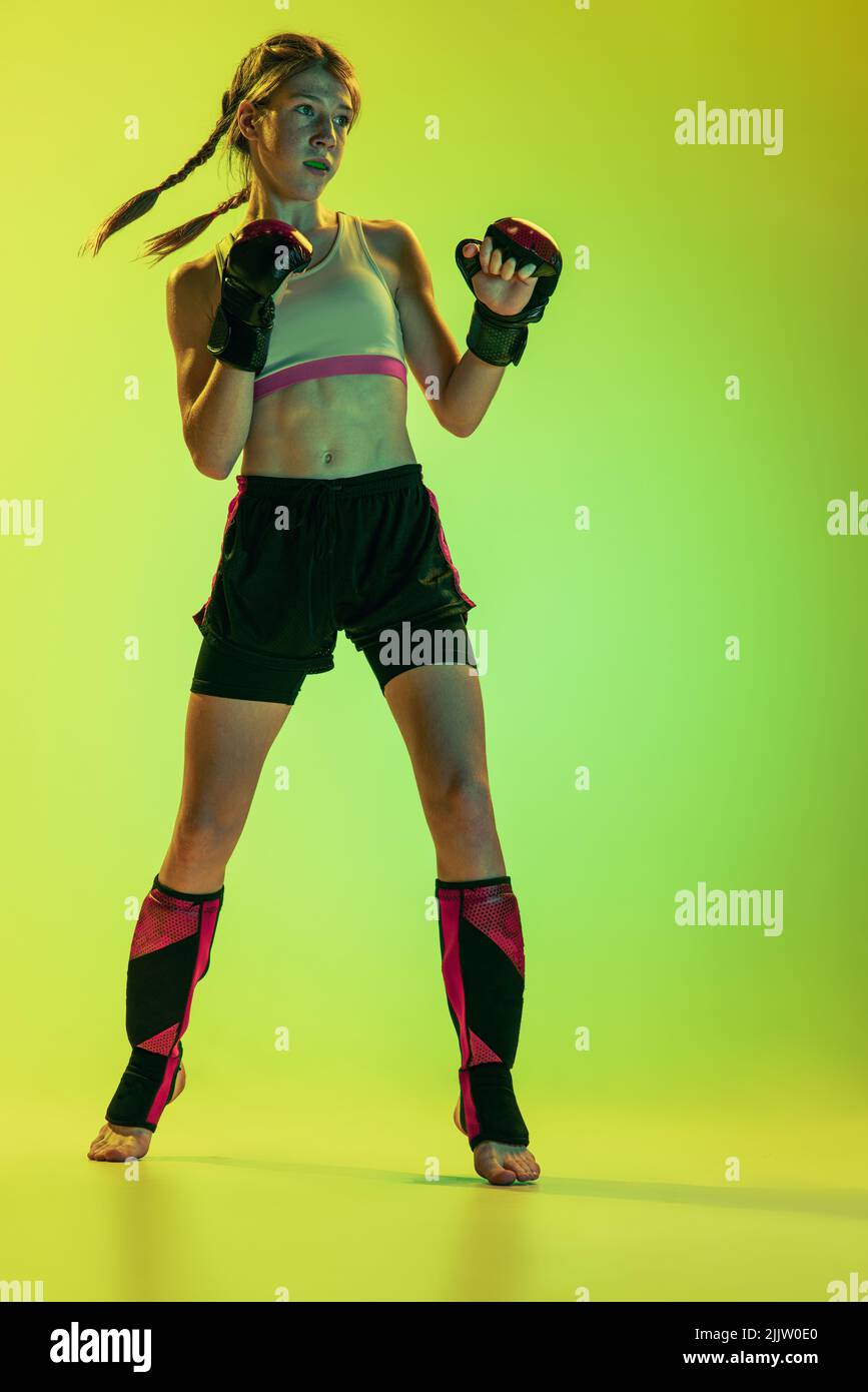 Dynamic portrait of athletic girl, MMA fighter training isolated on ...