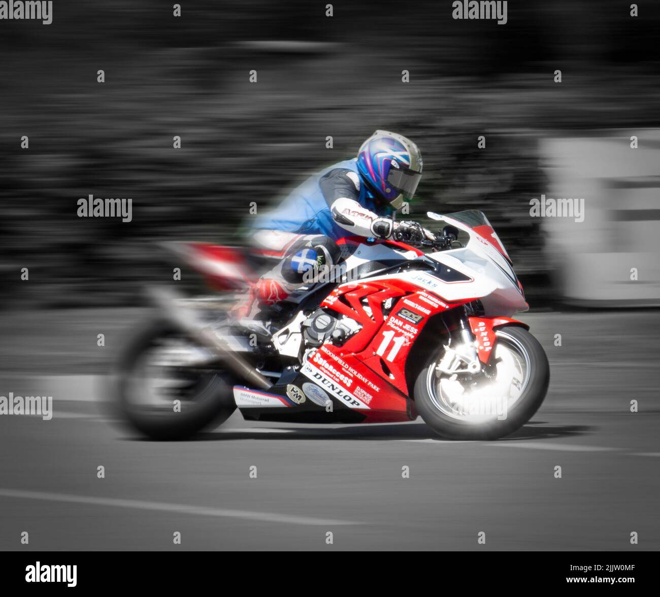 A panning shot of a biker riding a motorcycle on a track during the ...