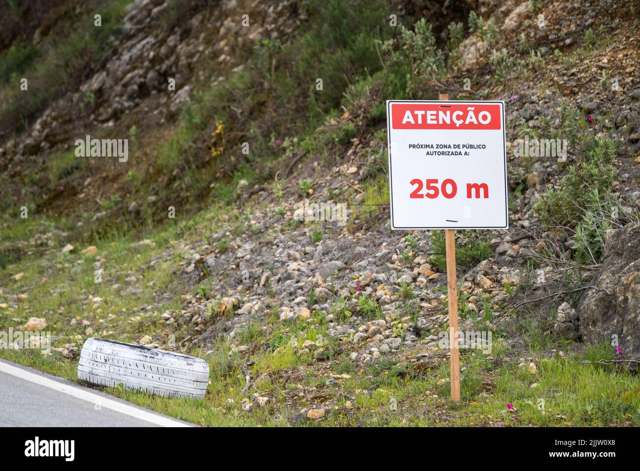 A close-up shot of a roadside warning sign "proximal zone de public is ...
