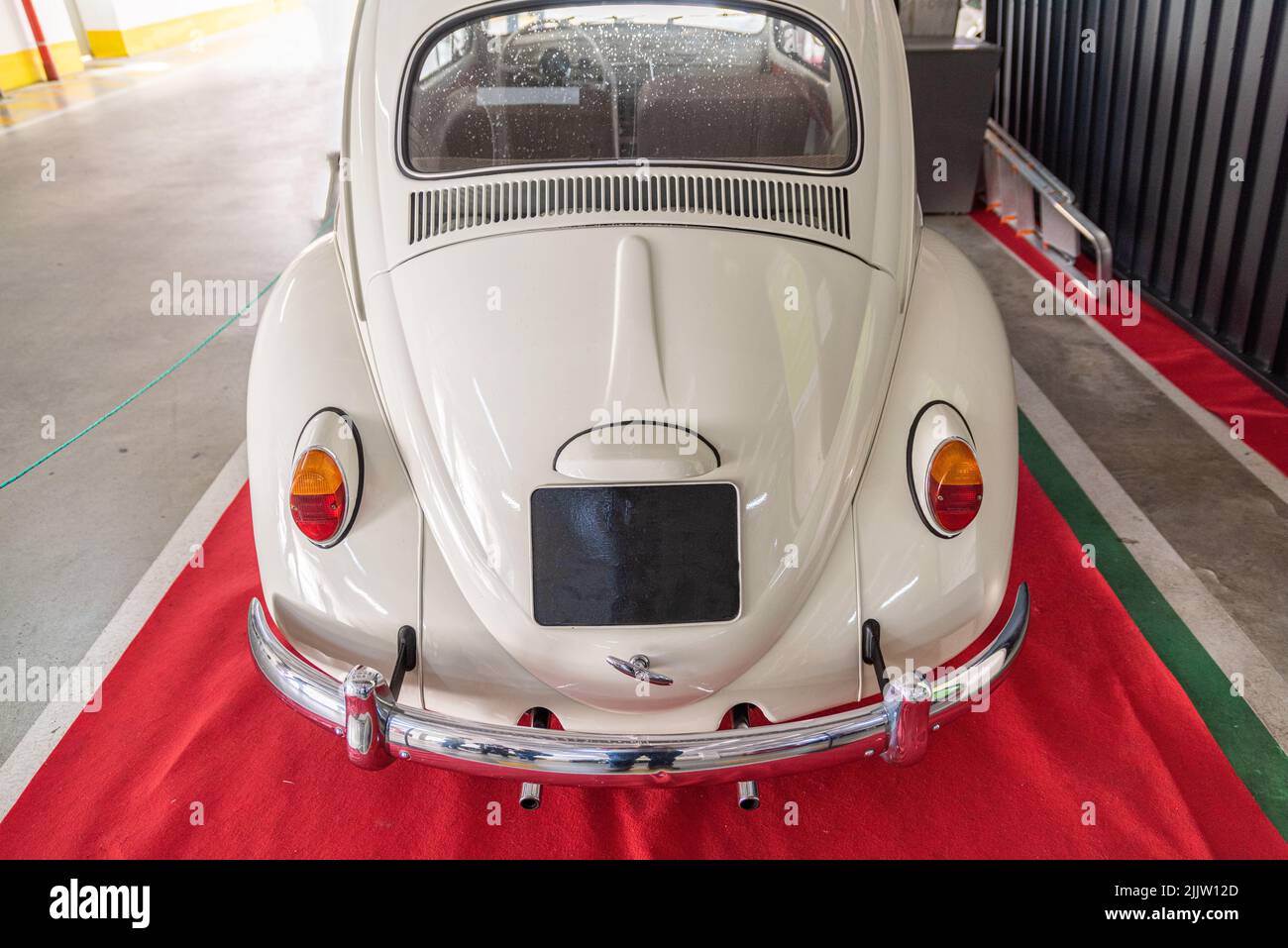 The back part of a vintage Volkswagen Beetle parked on red fabric Stock ...