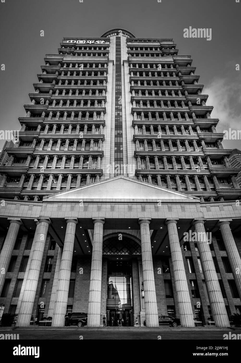 A vertical grayscale shot of a tall bank building in Shanghai, China ...