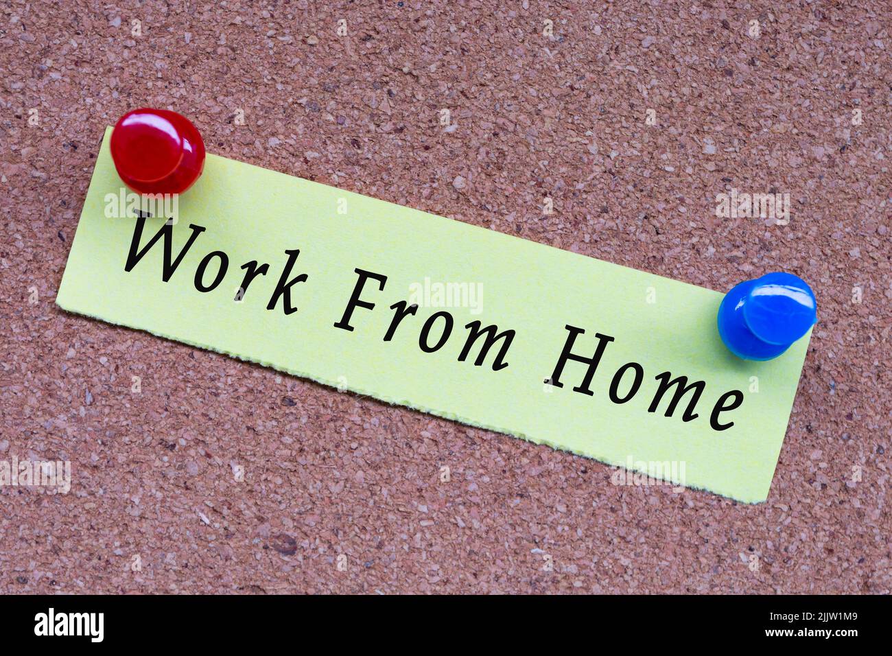 Work from home text on stick note and pinned to a cork notice board ...